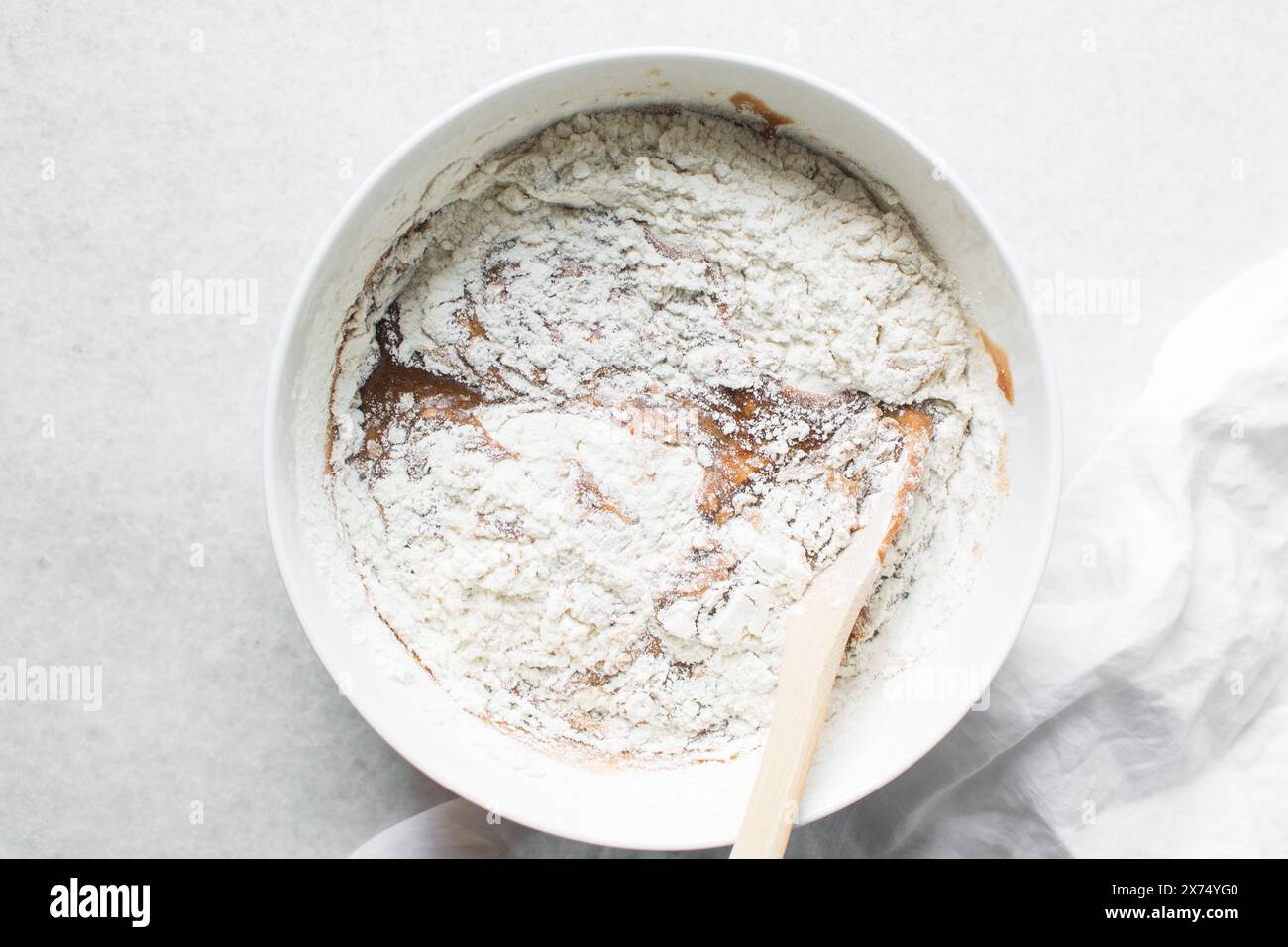 Flour being folded into sugar cookie dough, process of making sugar ...