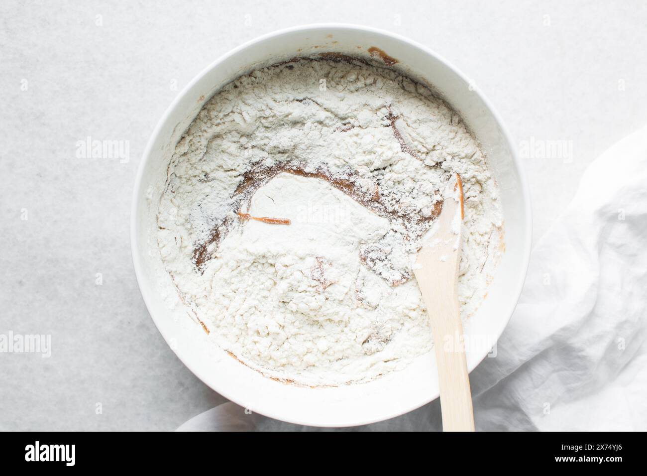 Flour being folded into sugar cookie dough, process of making sugar ...