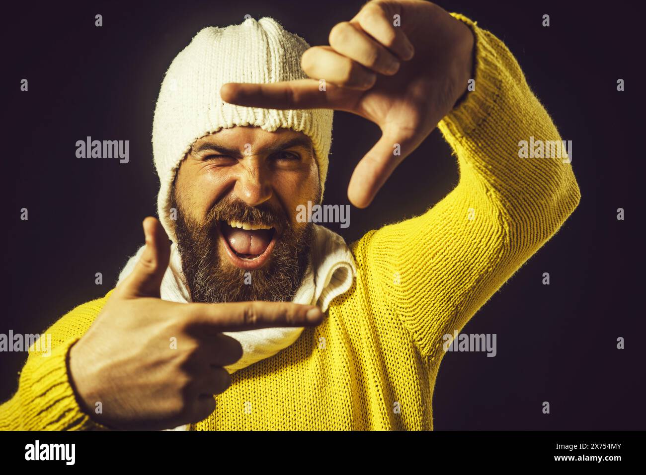 Handsome bearded man makes picture frame with fingers. Imaginary selfie ...