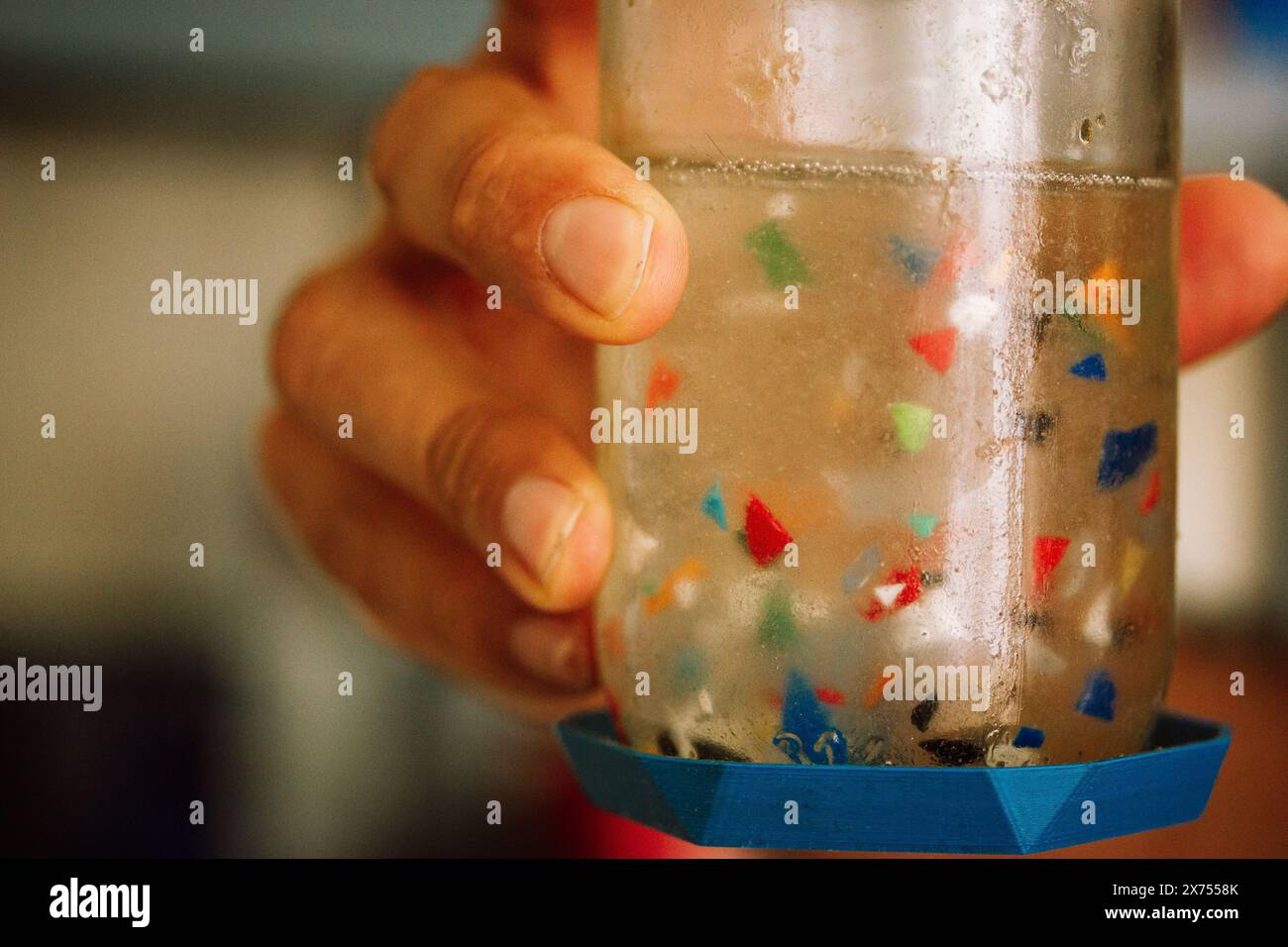 Colorful plastic parts floating inside of a bottle in a hand ...