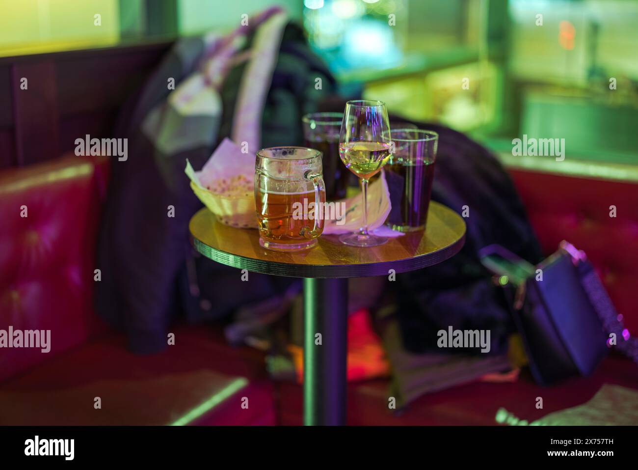 Close-up view of assorted drinks in glasses on a small bar table at a ...