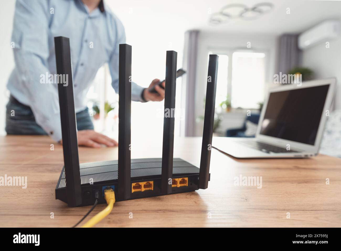 Man using modern wi-fi router on light table in room Stock Photo - Alamy