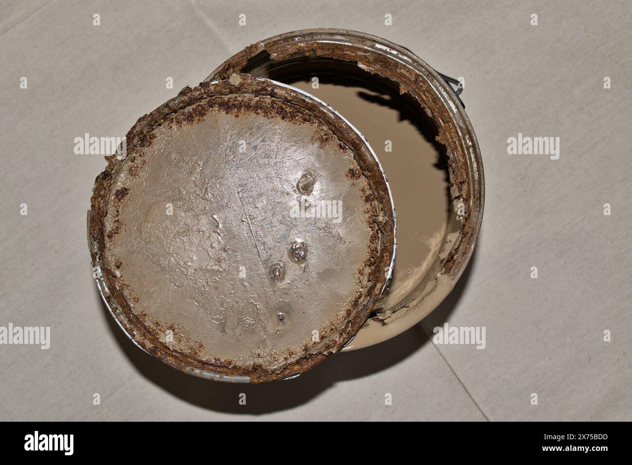 Rusted old metal paint tin with open lid on drop cloth brown expired ...