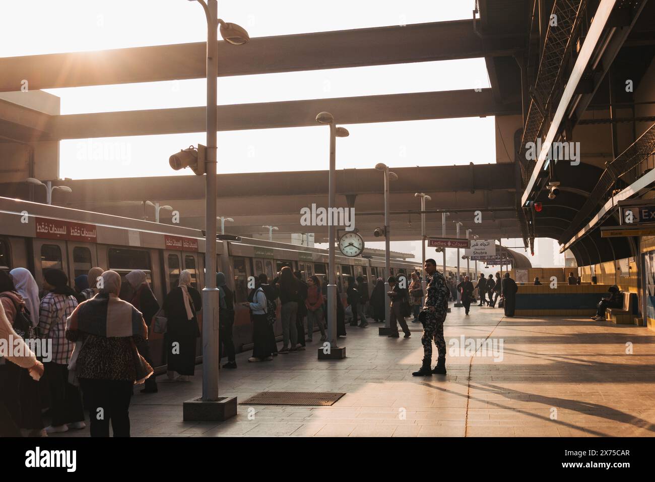 Commuters on a platform at Giza station on the Cairo Metro Line 2, early on a cool winter ...