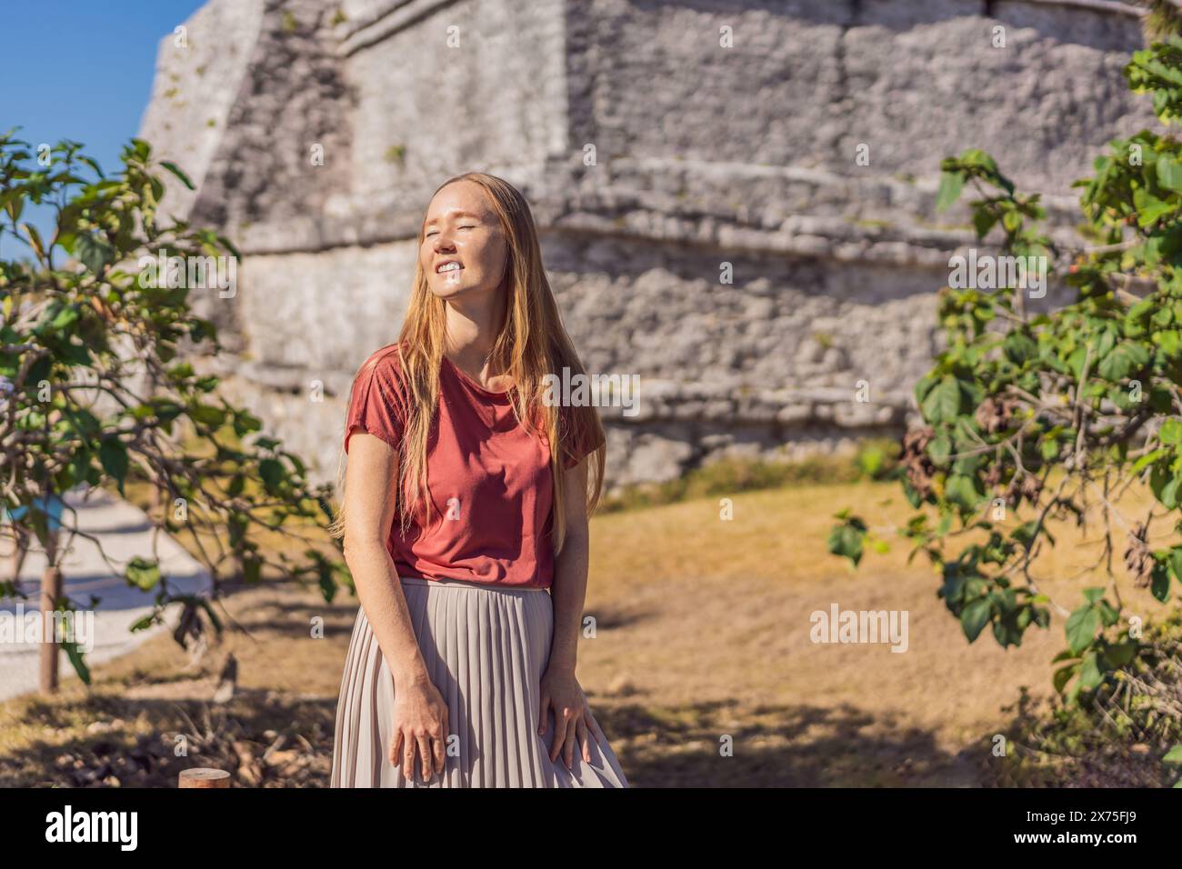 Woman tourist enjoying the view Pre-Columbian Mayan walled city of ...