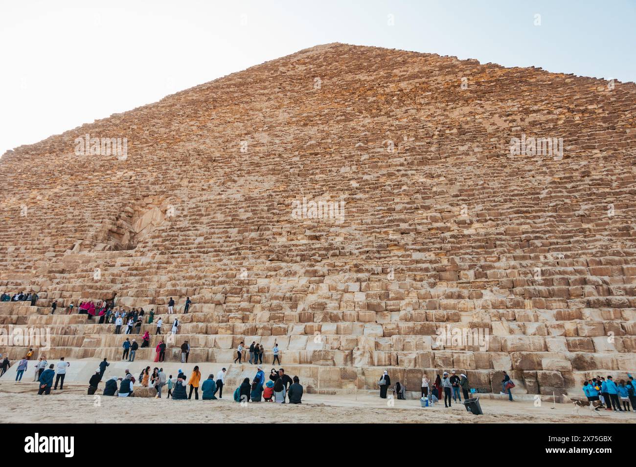 Tourists gather at the base of the Great Pyramid of Giza, Egypt ...