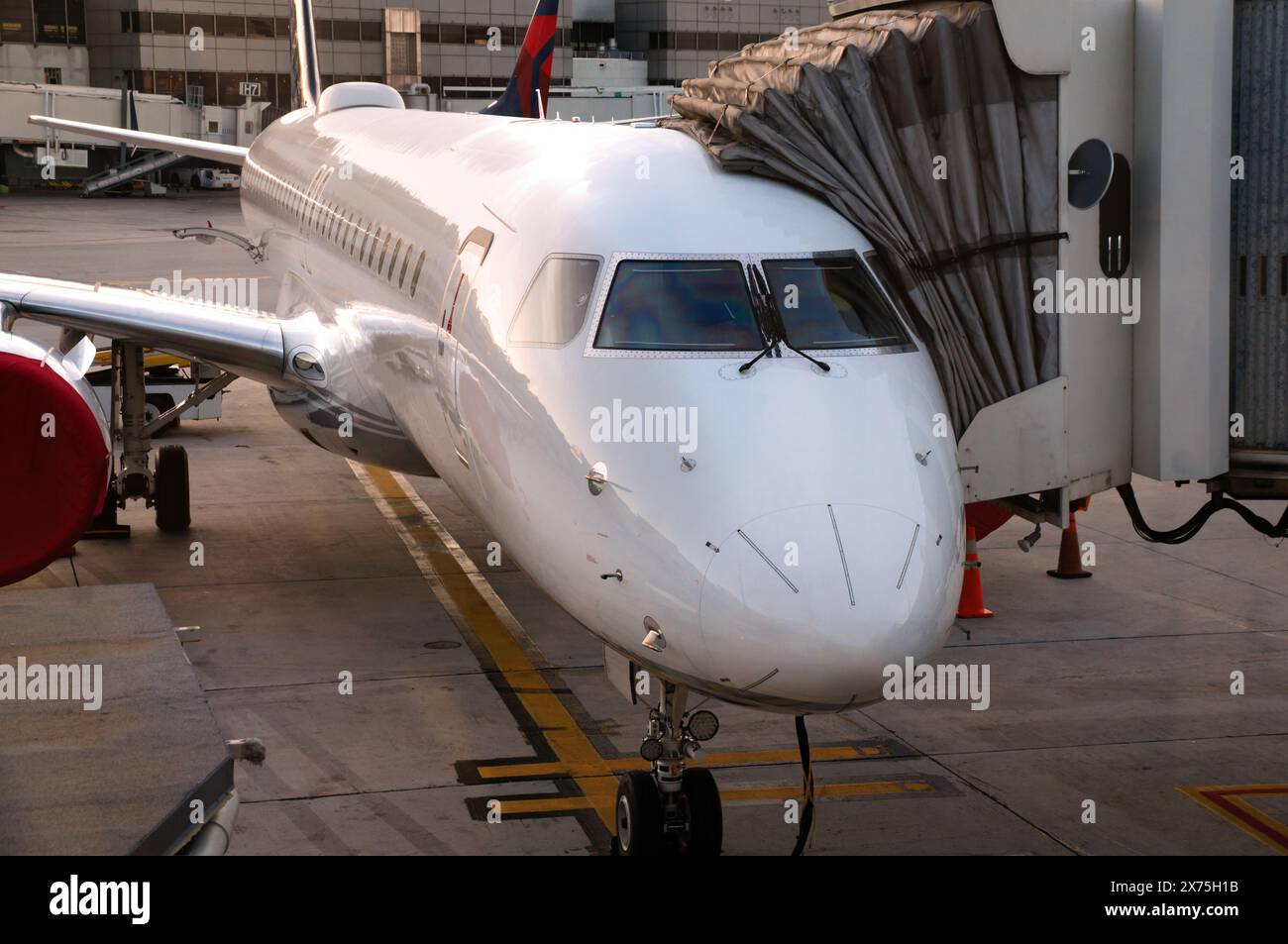 Front view of white modern jet airliner with attached passenger ...