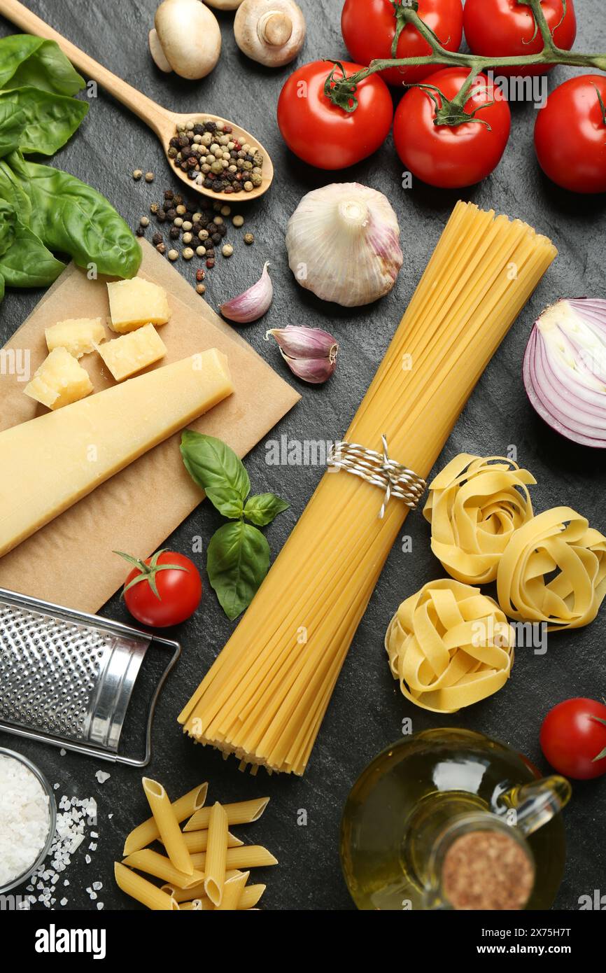 Different types of pasta, spices, garter and products on dark textured ...