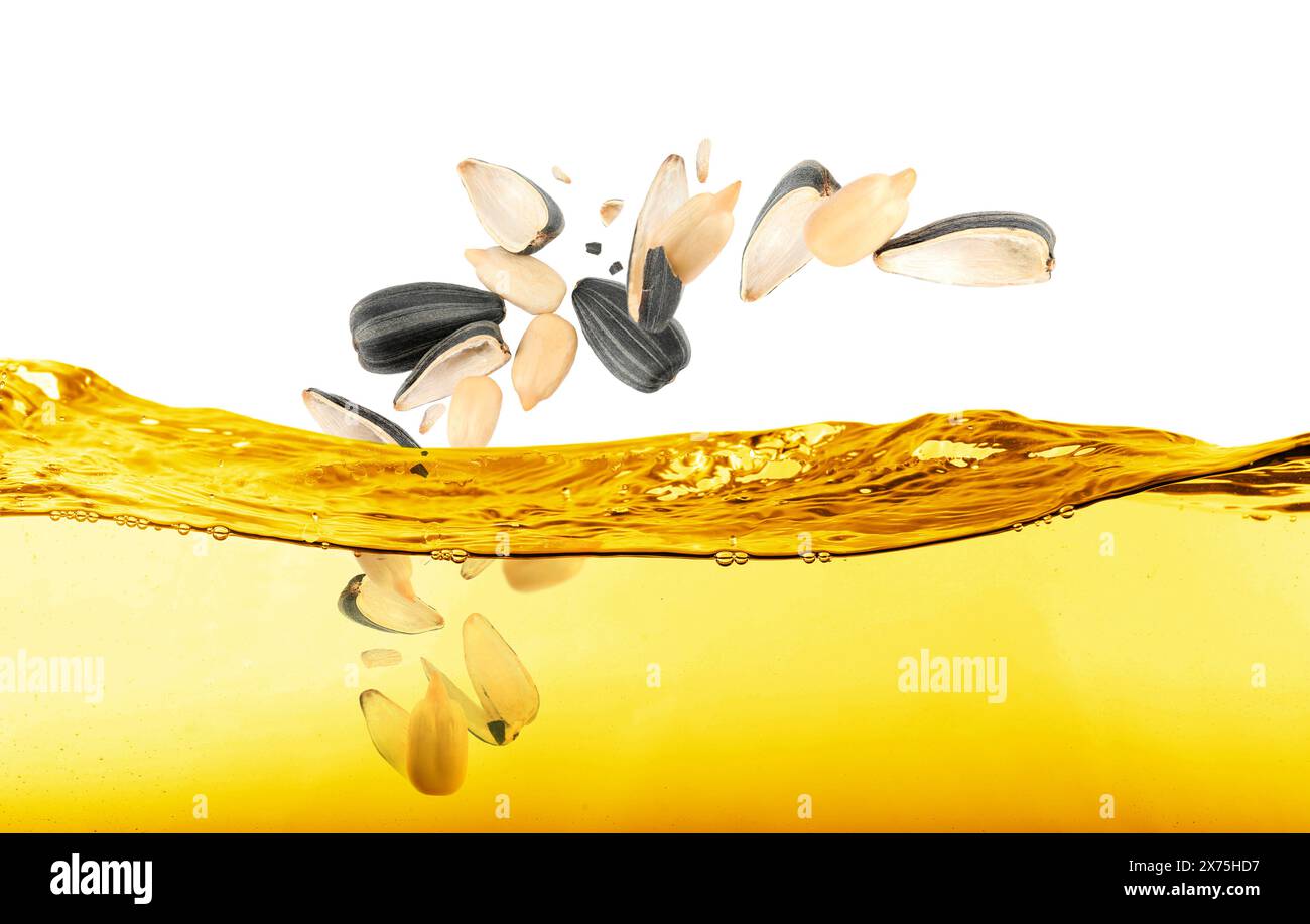 Sunflower seeds falling into cooking oil on white background Stock ...