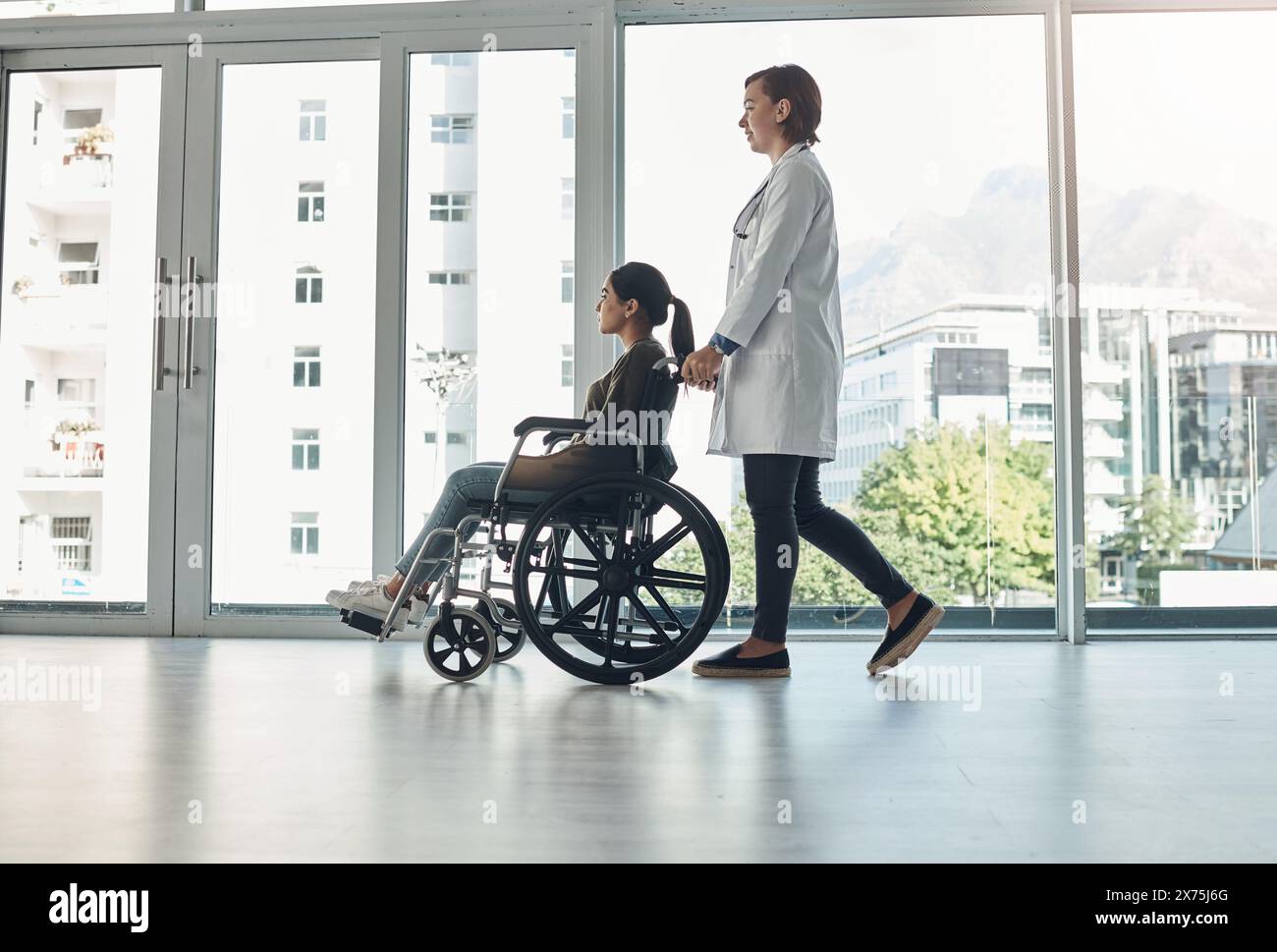 Wheelchair, doctor and walking with patient with disability in hospital ...