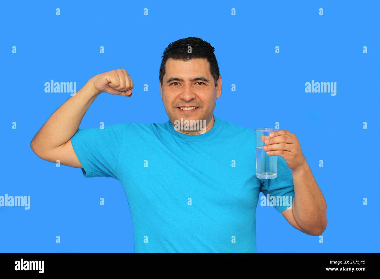 Dark-skinned Latino adult man shows his glass with still water to ...