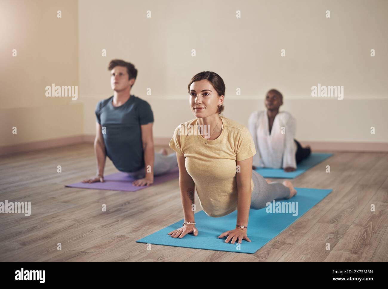 Yoga class, group diversity and stretching on mat with cobra pose ...