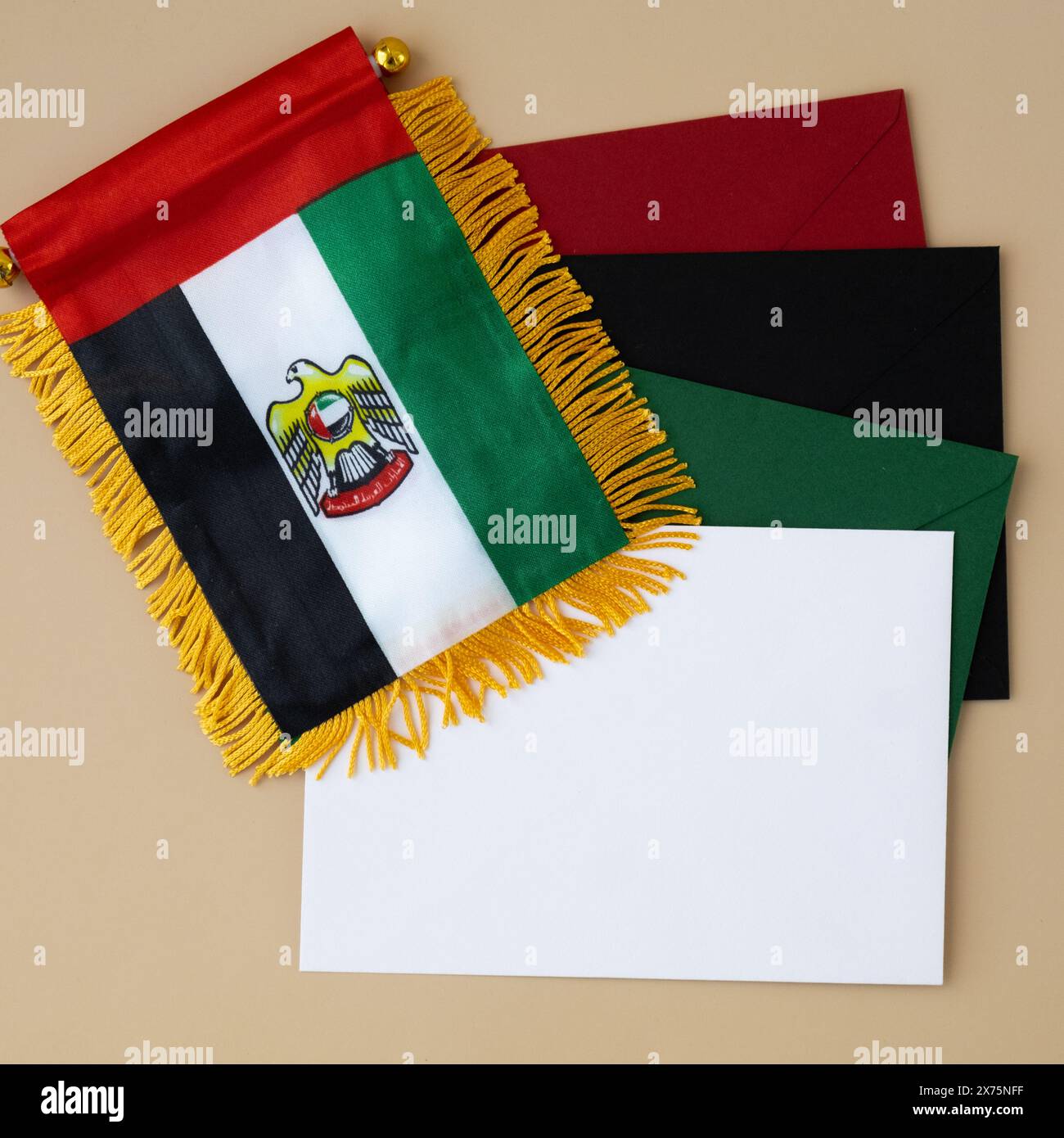Small flag of UAE on beige background with colorful envelopes. Copy ...
