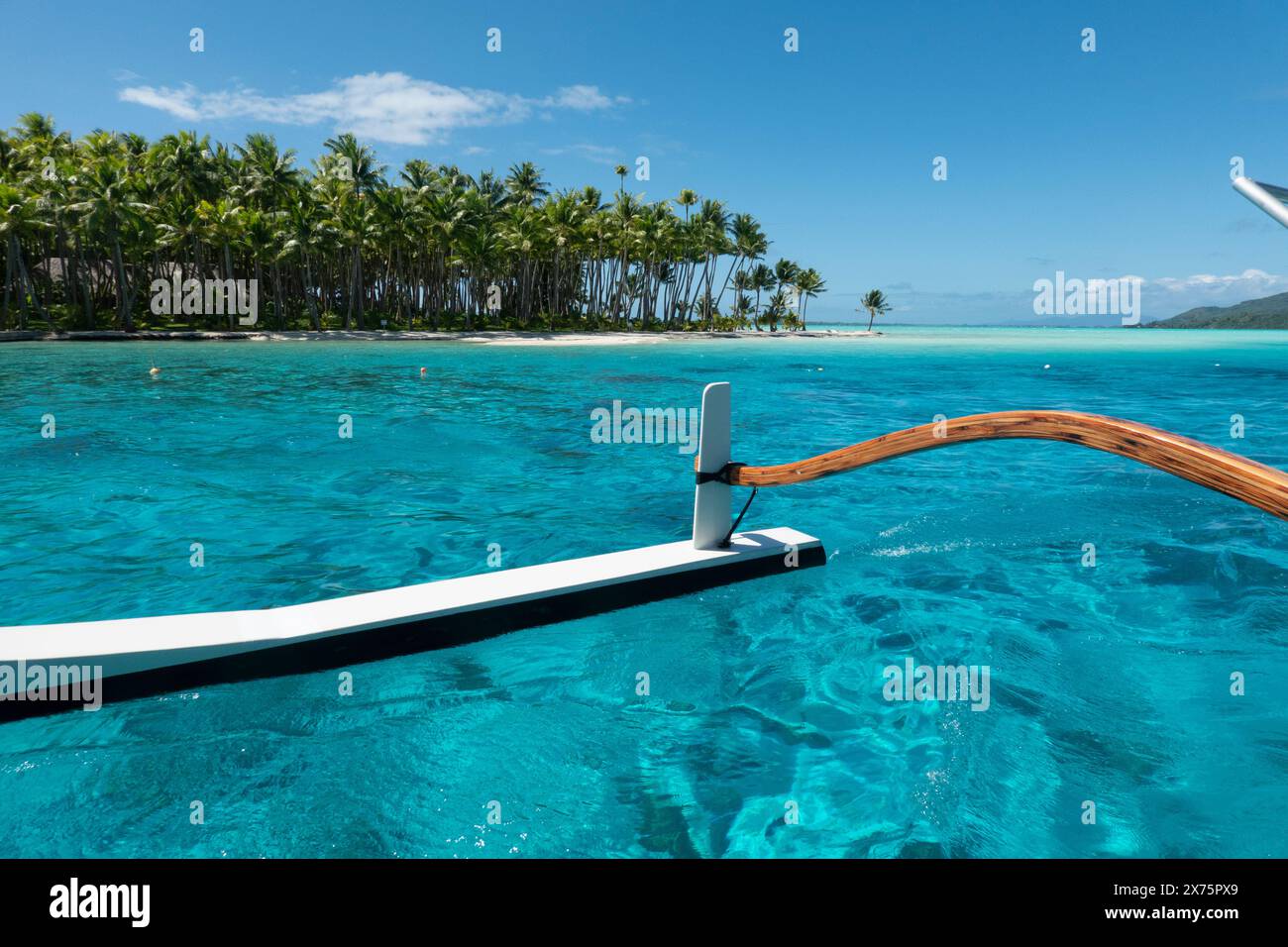 Side of a typical Polynesian Canoe over the lagoon and its turquoise ...