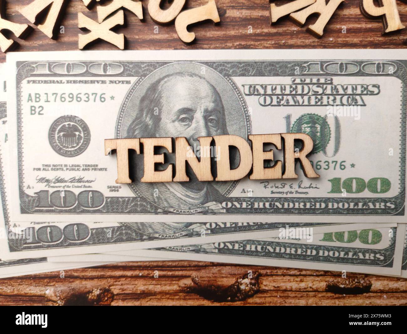 Top view wooden word and banknotes with text TENDER on a wooden ...