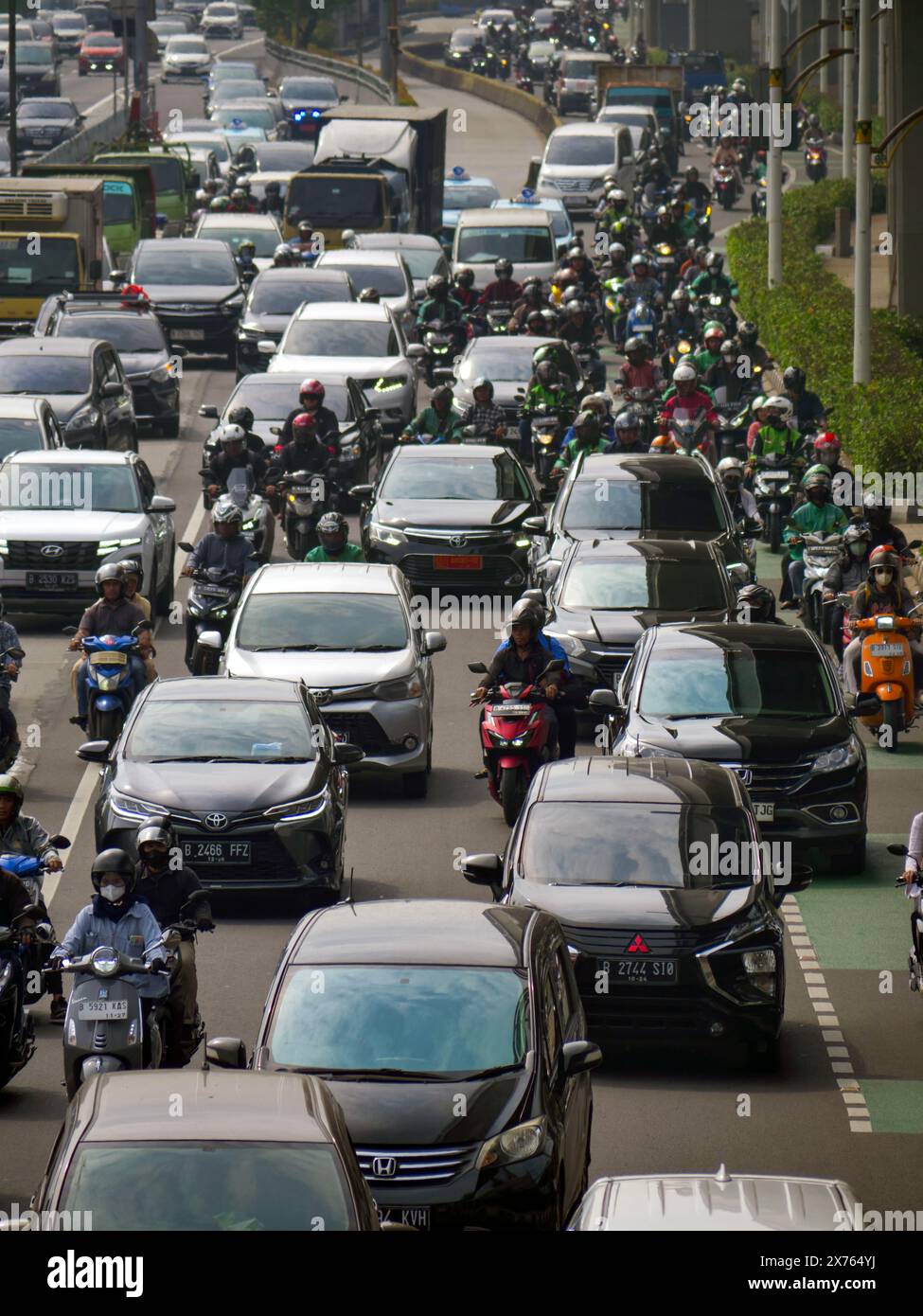Jakarta, Indonesia-May 10, 2024: Busy traffic with chaotic vehicles scrambling on the highway ...