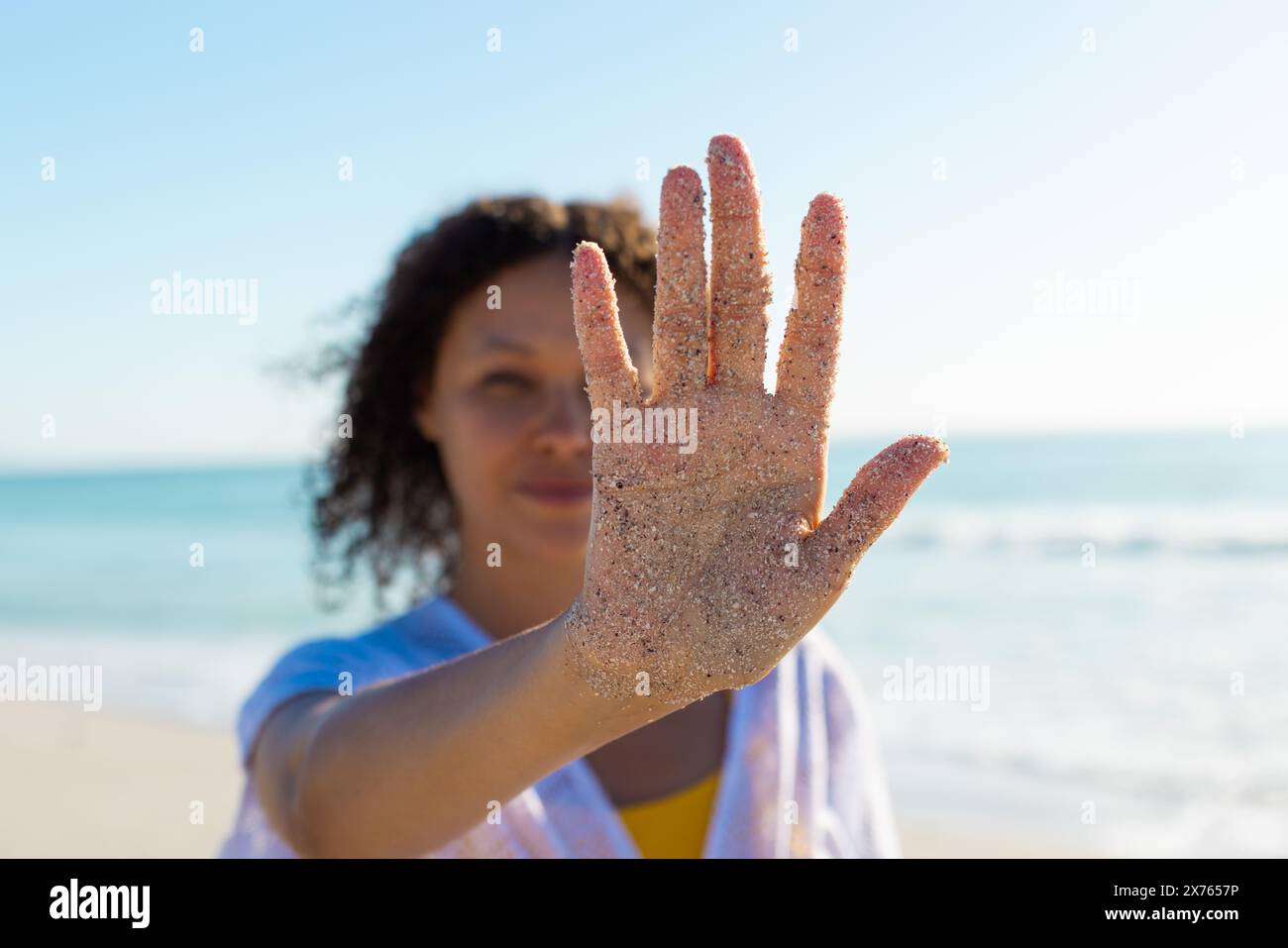 At beach, biracial young woman showing sandy hand Stock Photo - Alamy