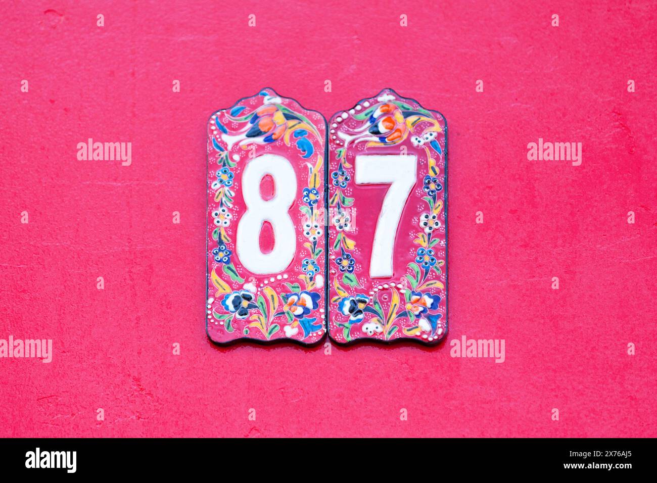 Colorful earthenware plate with a number 87 in its middle. The plate is ...