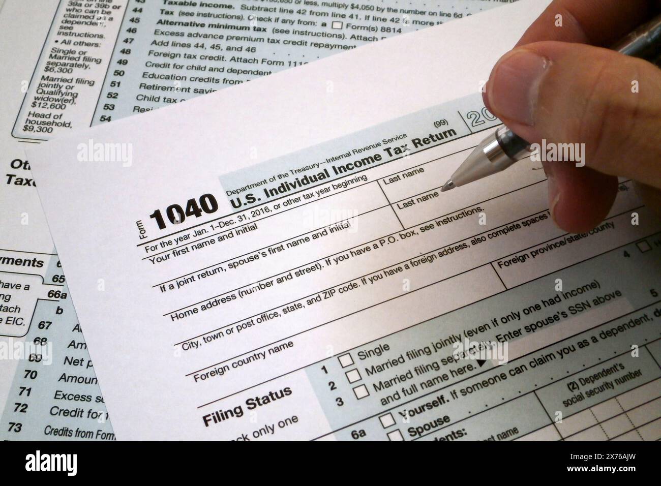 A ballpoint pen between the fingers of a man filling a U.S. Individual ...