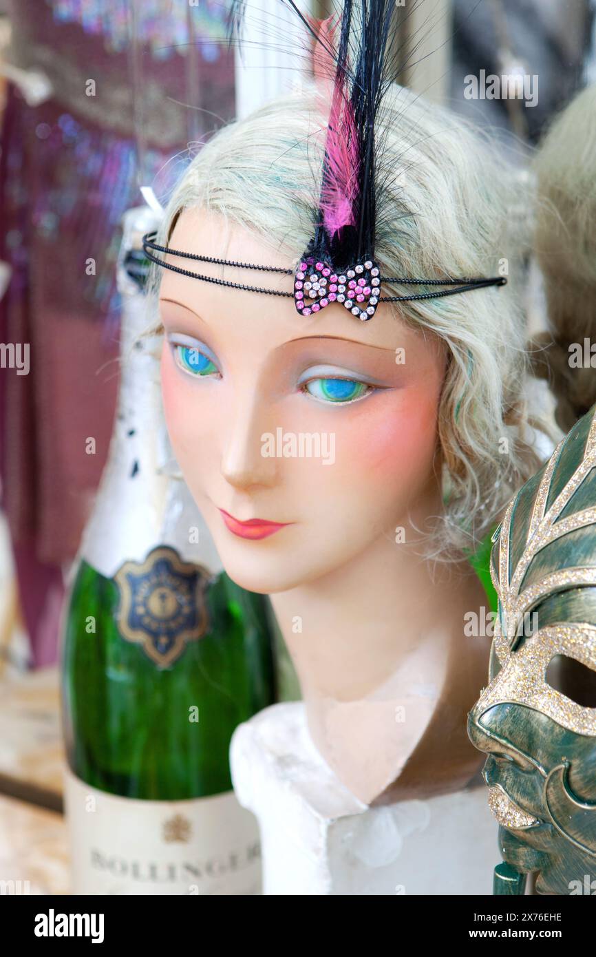 A portrait of a 1920's female mannequin bust with a feather head dress ...