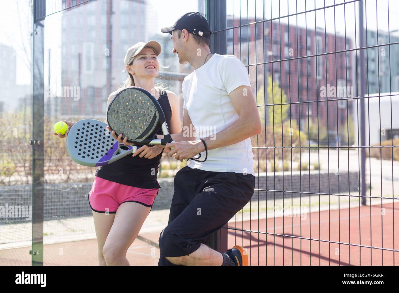 Portrait of two smiling sportsman's posing on padel court outdoor with ...