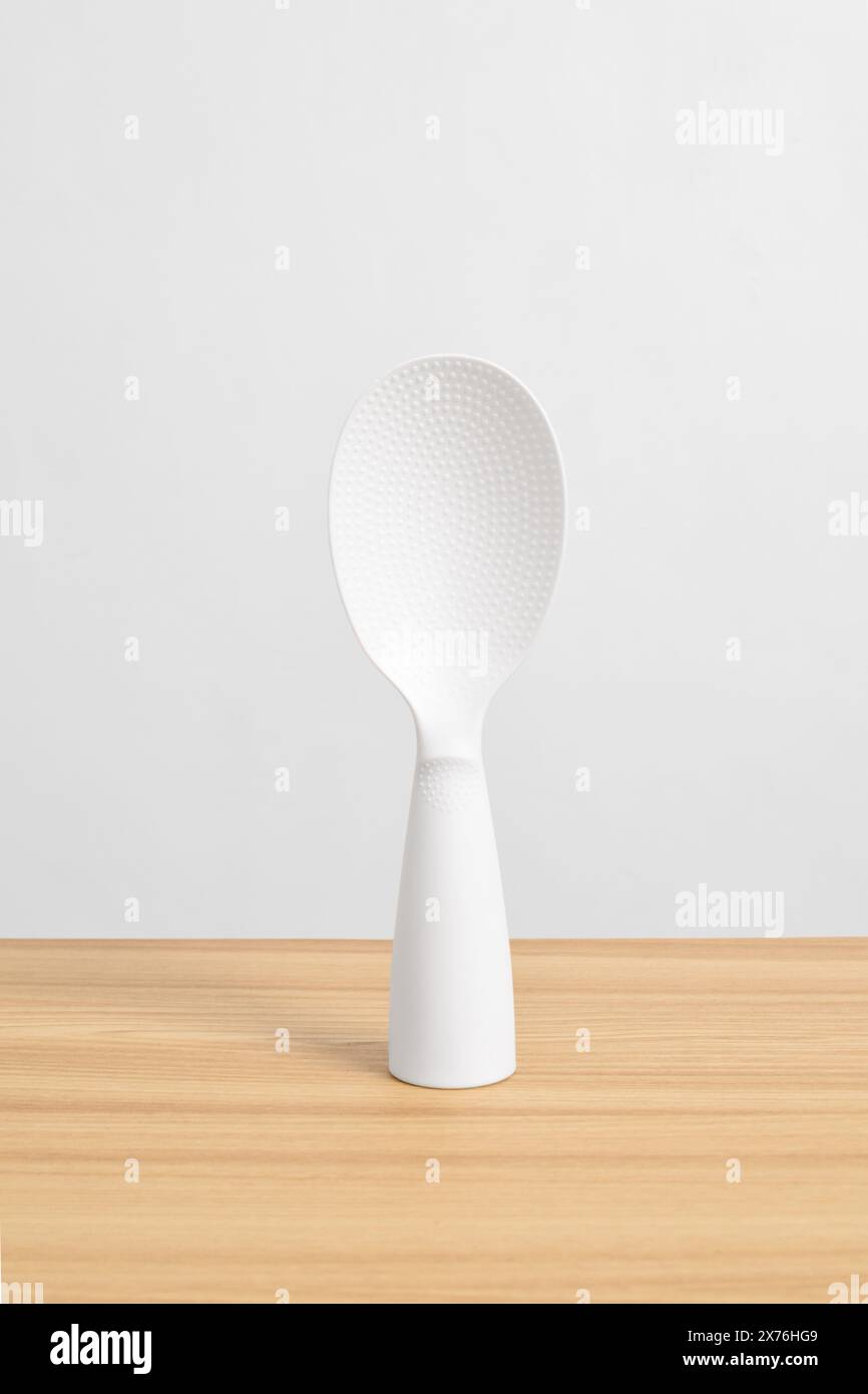 White rice spoon or rice ladle on wooden table. White plastic rice ...