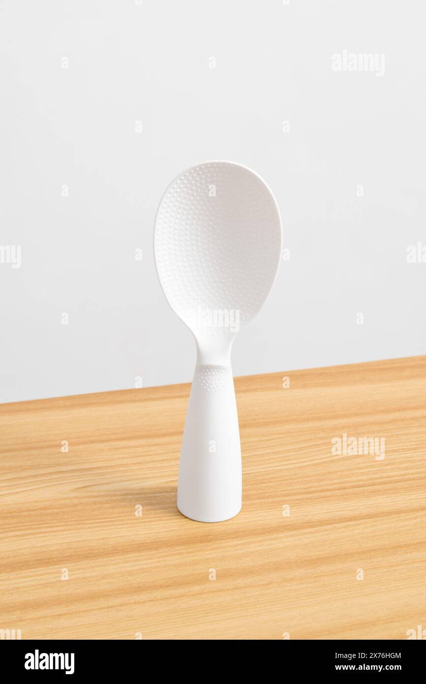 White rice spoon or rice ladle on wooden table. White plastic rice ...