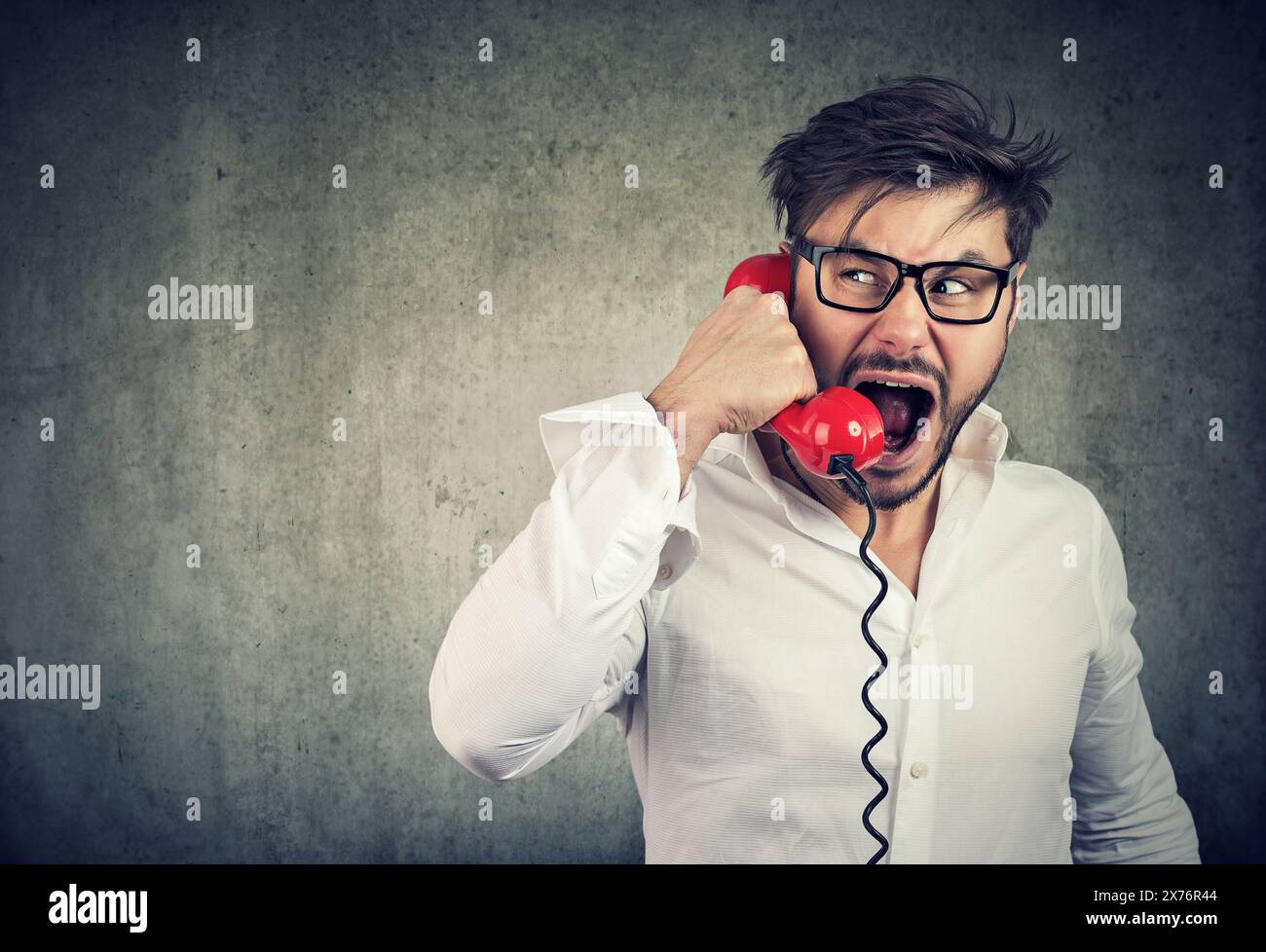 Angry young man screaming on a phone Stock Photo - Alamy