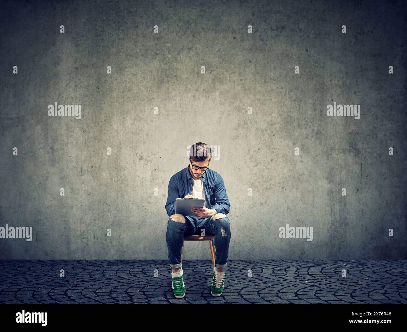 man sitting on a chair filling out a job application form Stock Photo ...