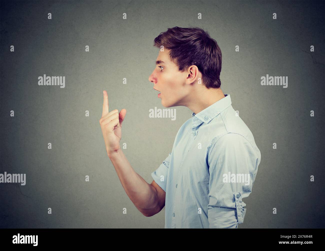 Side profile of a shocked young man looking at his finger Stock Photo ...