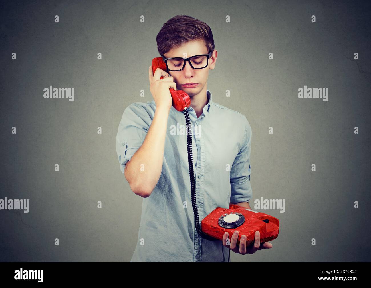 Portrait of a sad man talking on a telephone Stock Photo - Alamy
