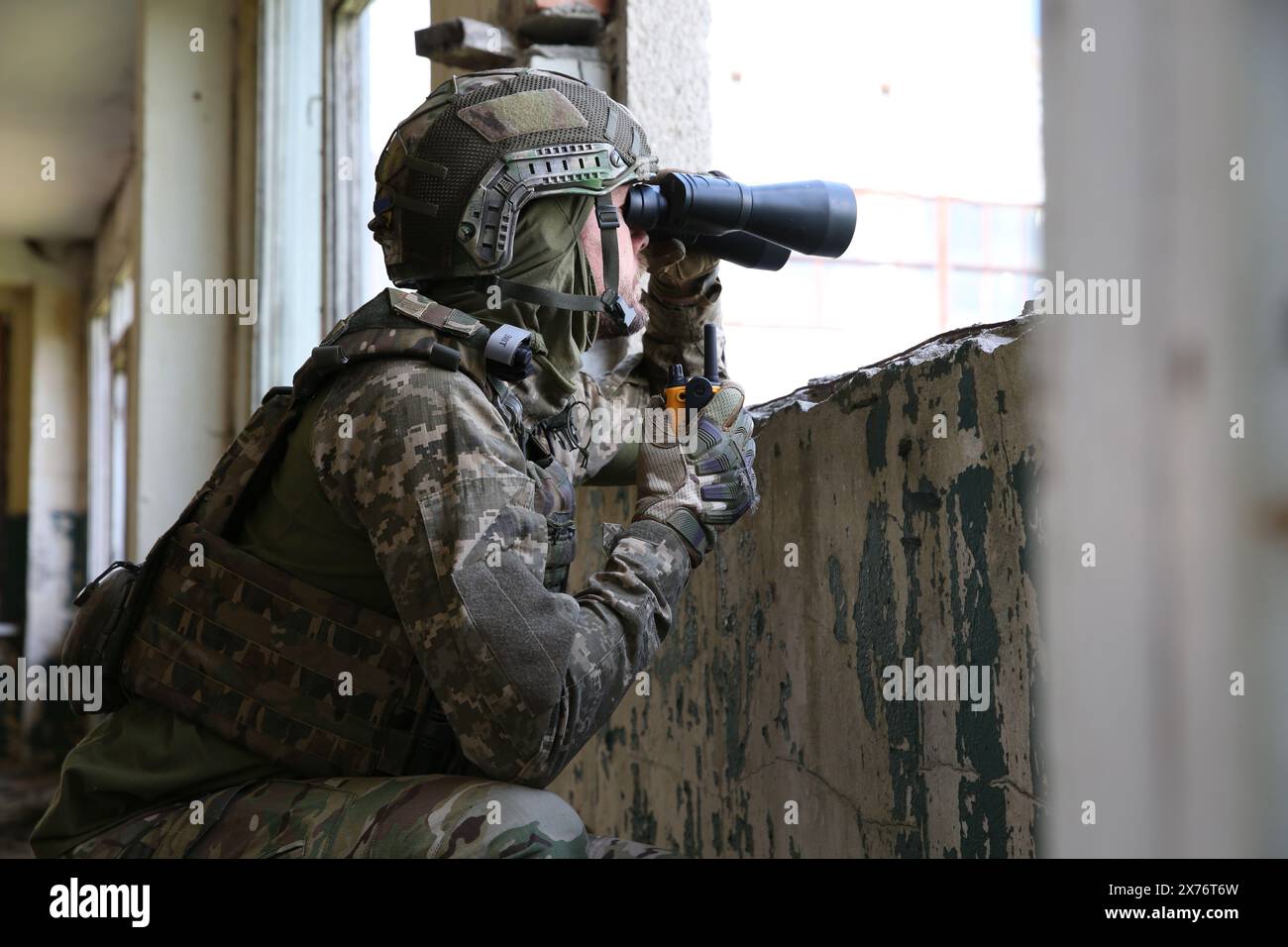 Military mission. Soldier in uniform with binoculars inside abandoned ...