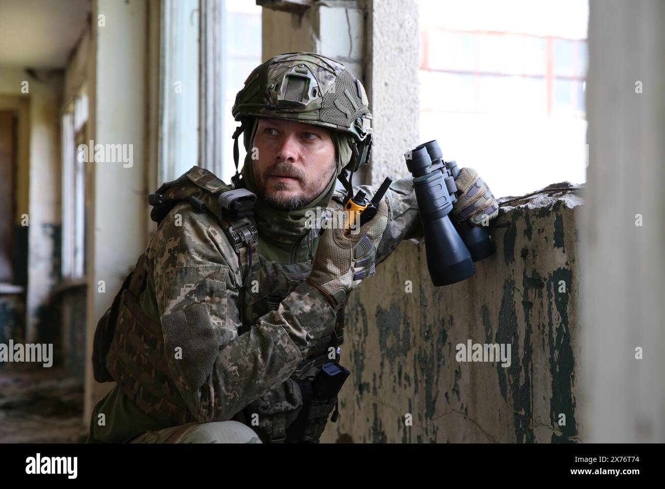 Military mission. Soldier in uniform with binoculars inside abandoned ...
