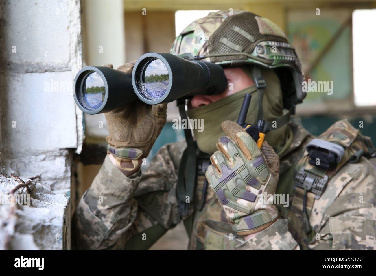 Military mission. Soldier in uniform with binoculars inside abandoned ...