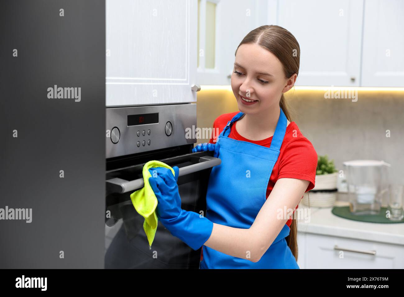 Woman cleaning electric oven with rag in kitchen Stock Photo - Alamy