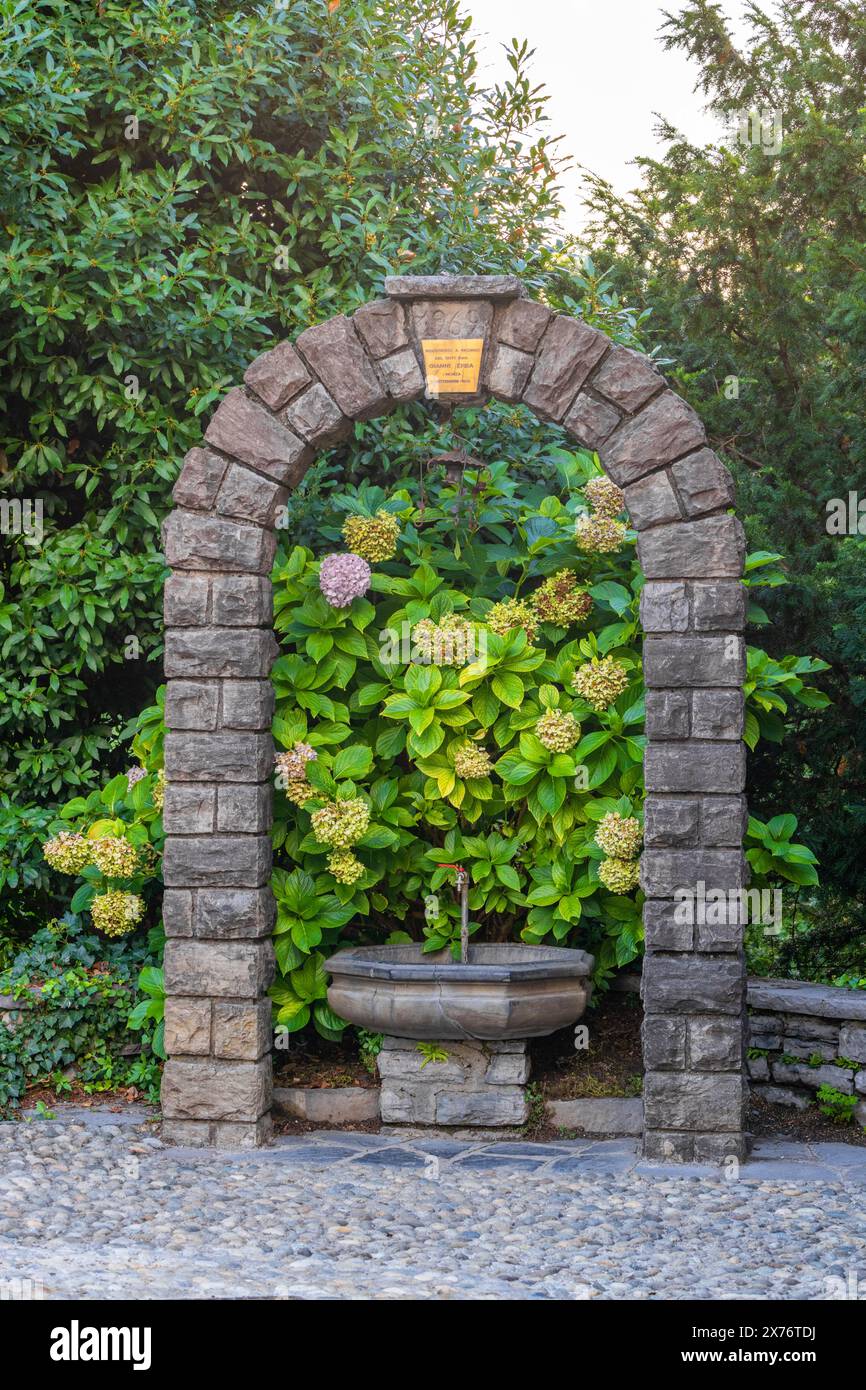 stone arch with fountain and hydrangeas in garden Stock Photo - Alamy