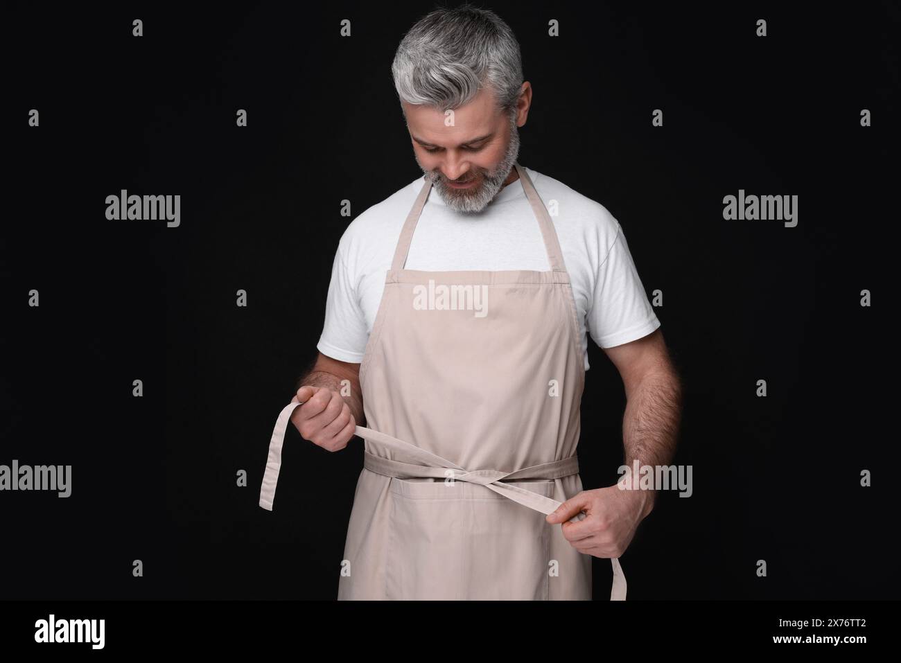 Man wearing kitchen apron on black background. Mockup for design Stock ...