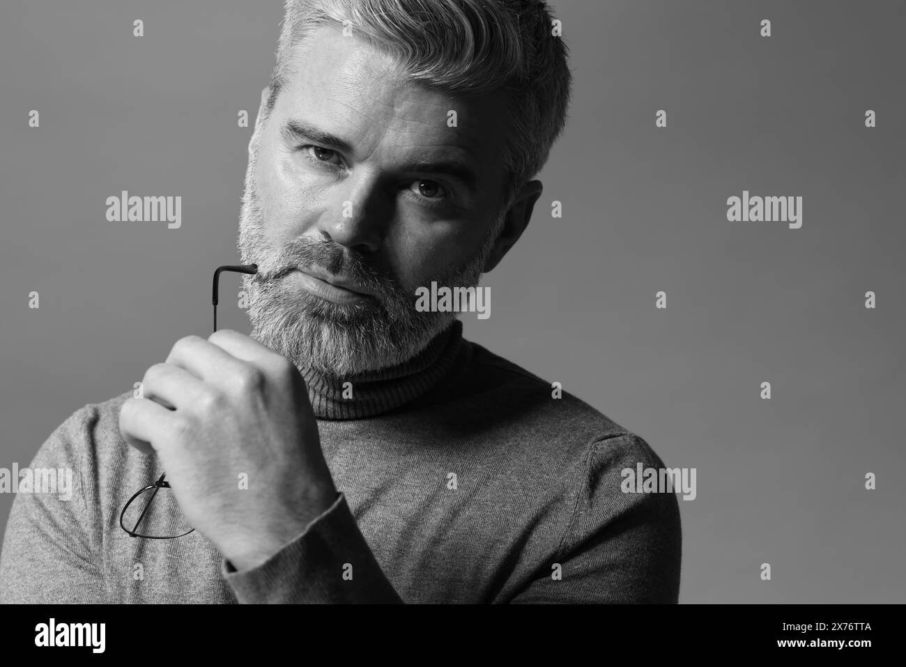 Portrait of handsome man on grey background. Black and white effect ...