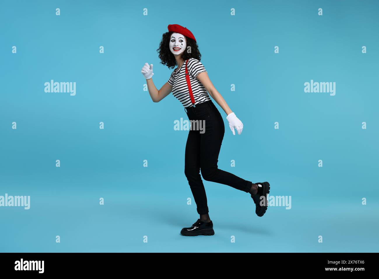 Funny mime with beret posing on light blue background Stock Photo - Alamy
