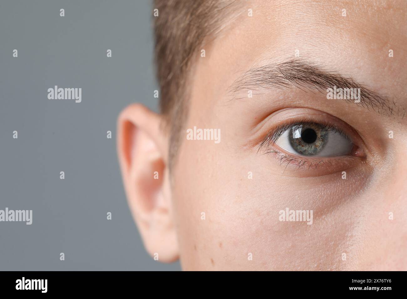 Perfect vision. Man with beautiful eyes on grey background, closeup ...