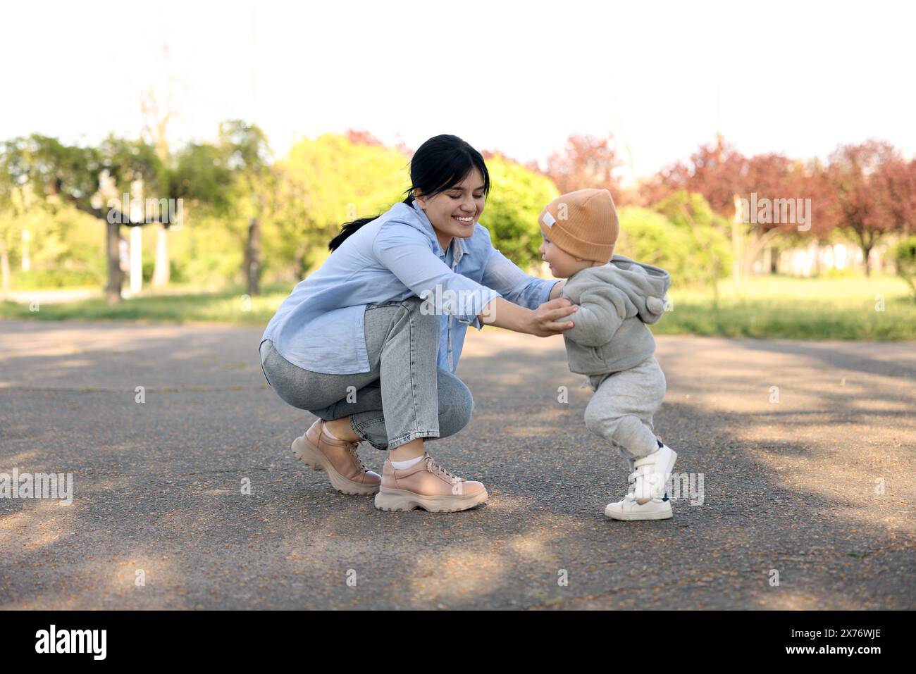 Mother teaching her baby how to walk outdoors Stock Photo - Alamy