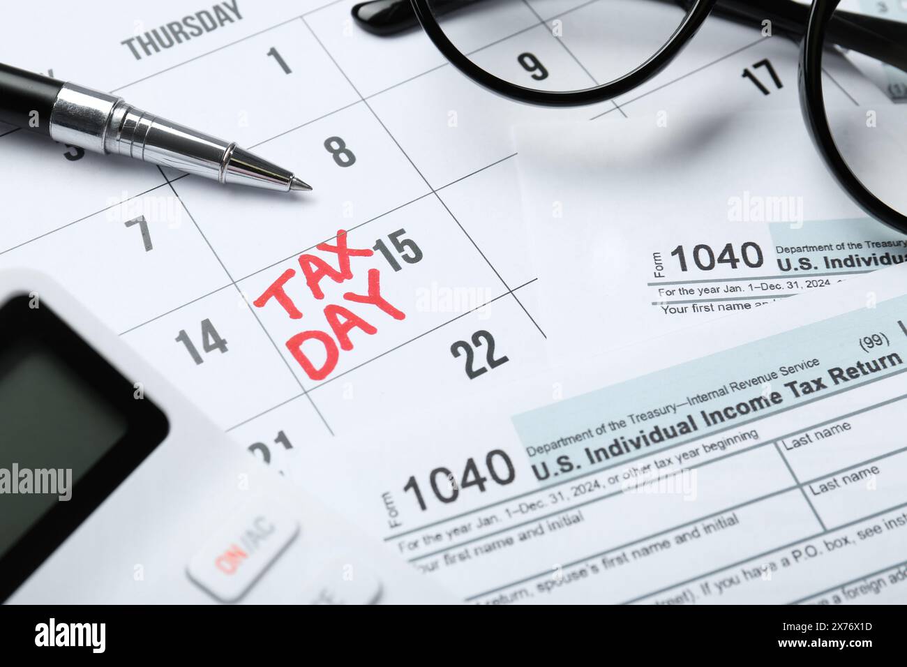 Calendar with date reminder about tax day, documents, glasses, pen and ...