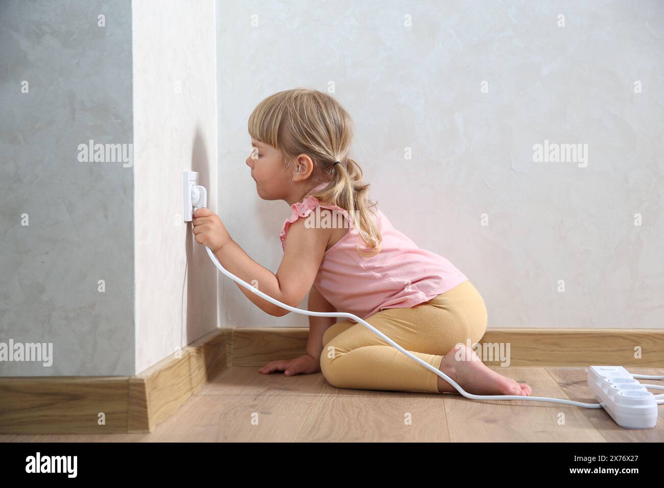 Little child playing with electrical socket and power strip plug at ...