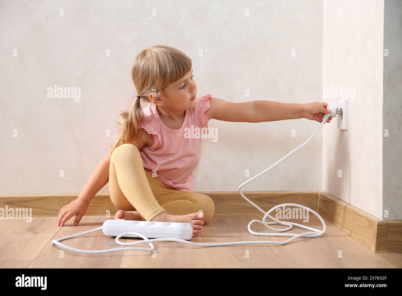 Little child playing with electrical socket and power strip plug at ...