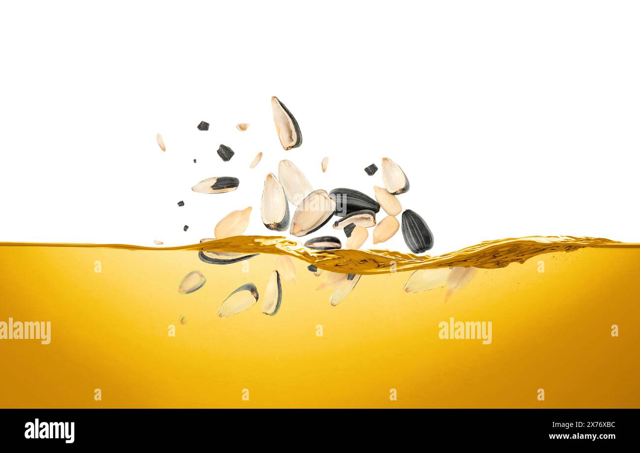 Sunflower seeds falling into cooking oil on white background Stock ...