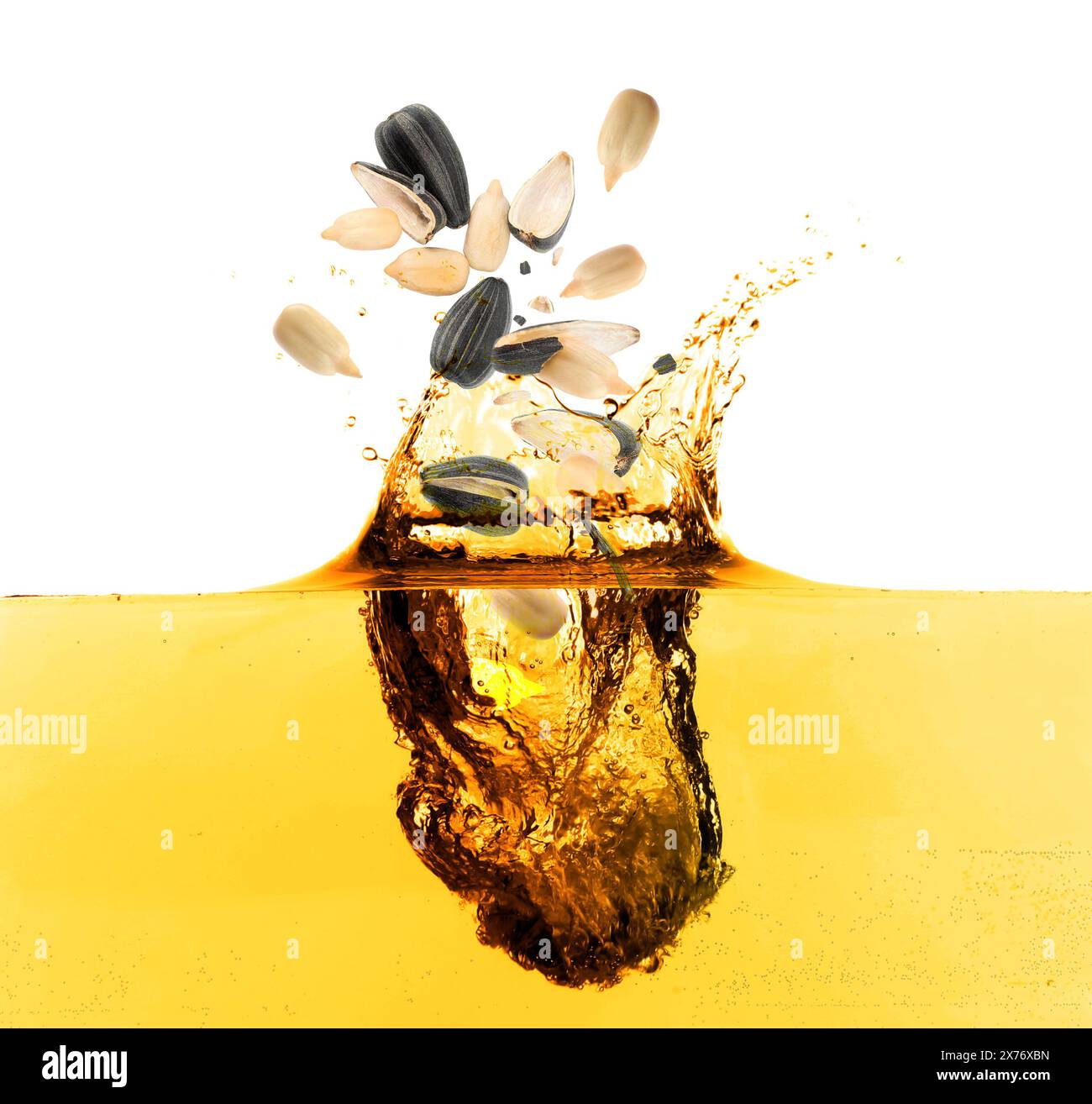 Sunflower seeds falling into cooking oil on white background Stock ...