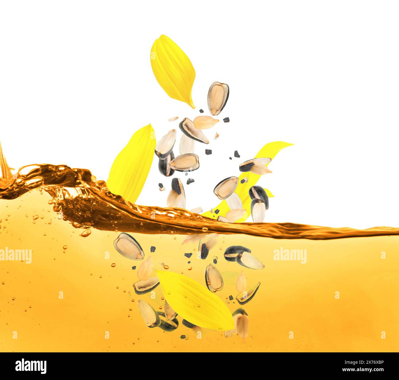Sunflower seeds and petals falling into cooking oil on white background ...