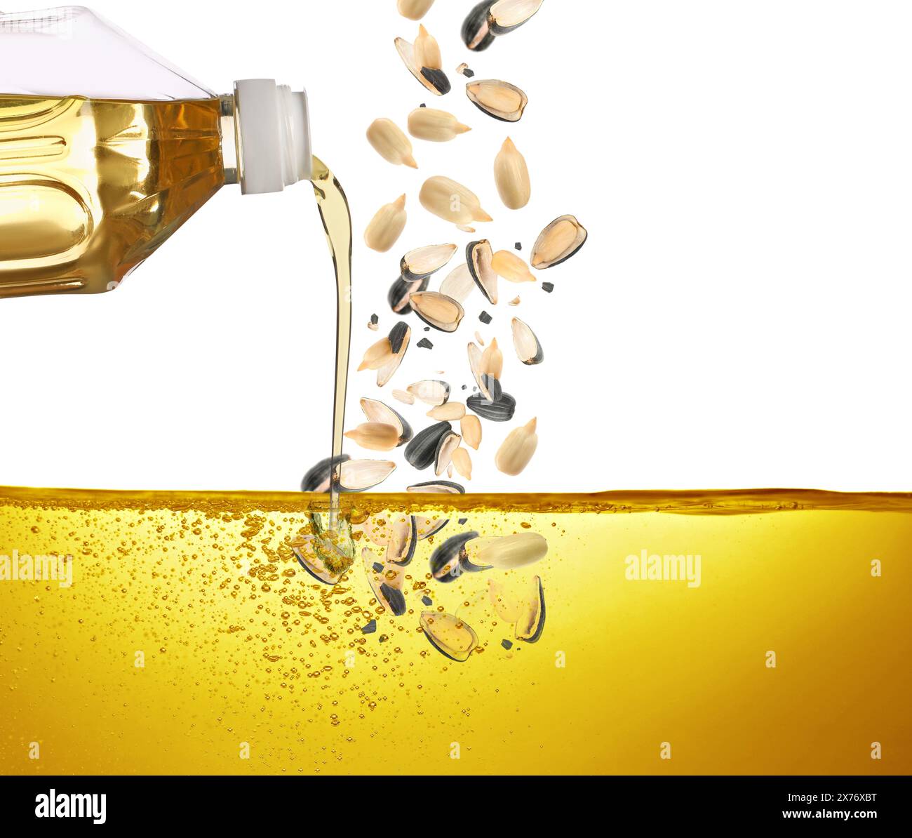 Pouring sunflower oil and falling seeds on white background Stock Photo ...