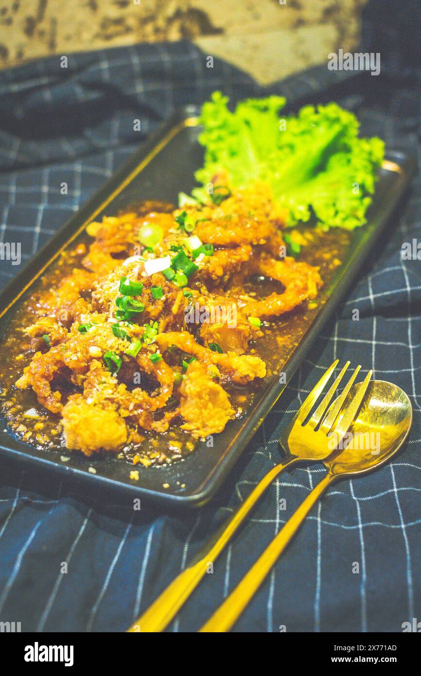 squid breaded then deep fried then coated in garlic sauce Stock Photo ...