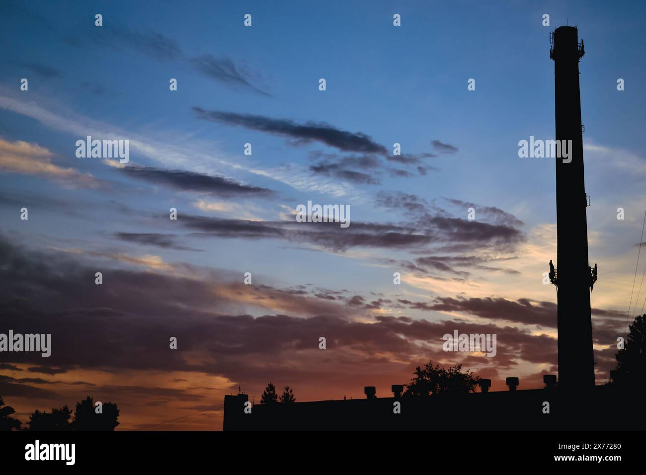 Silhouette of a boiler house chimney against the background of an ...